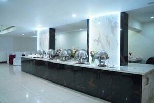 Uma área de recepção moderna com balcão de mármore, vários pontos de atendimento de alimentação e piso revestido de azulejos.