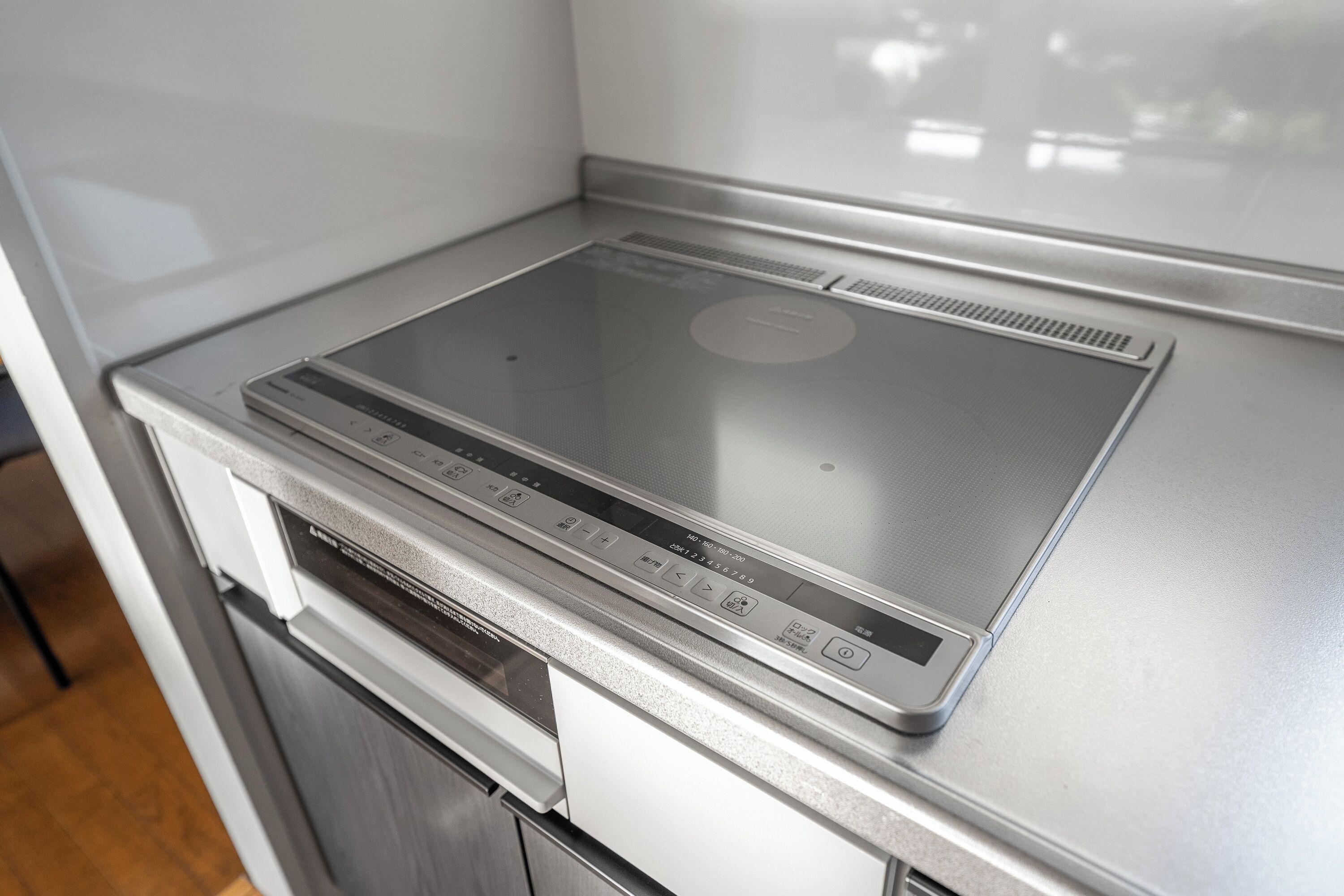 Cozinha moderna com fogão de indução embutido e máquina de lavar louça.