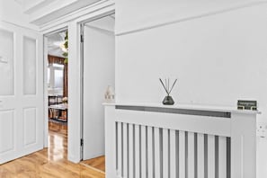 Uma área de recepção de hotel com um balcão branco, uma pequena decoração em formato de casa e uma placa com a inscrição 'CORY NIGHT STAYS'.