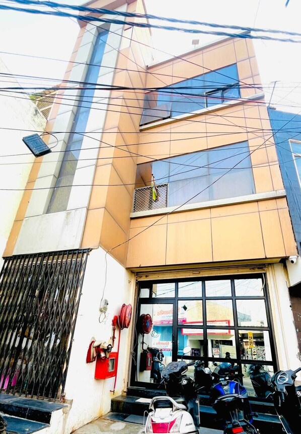 Um edifício com uma grande janela de vidro, um portão de metal e uma motocicleta estacionada.
