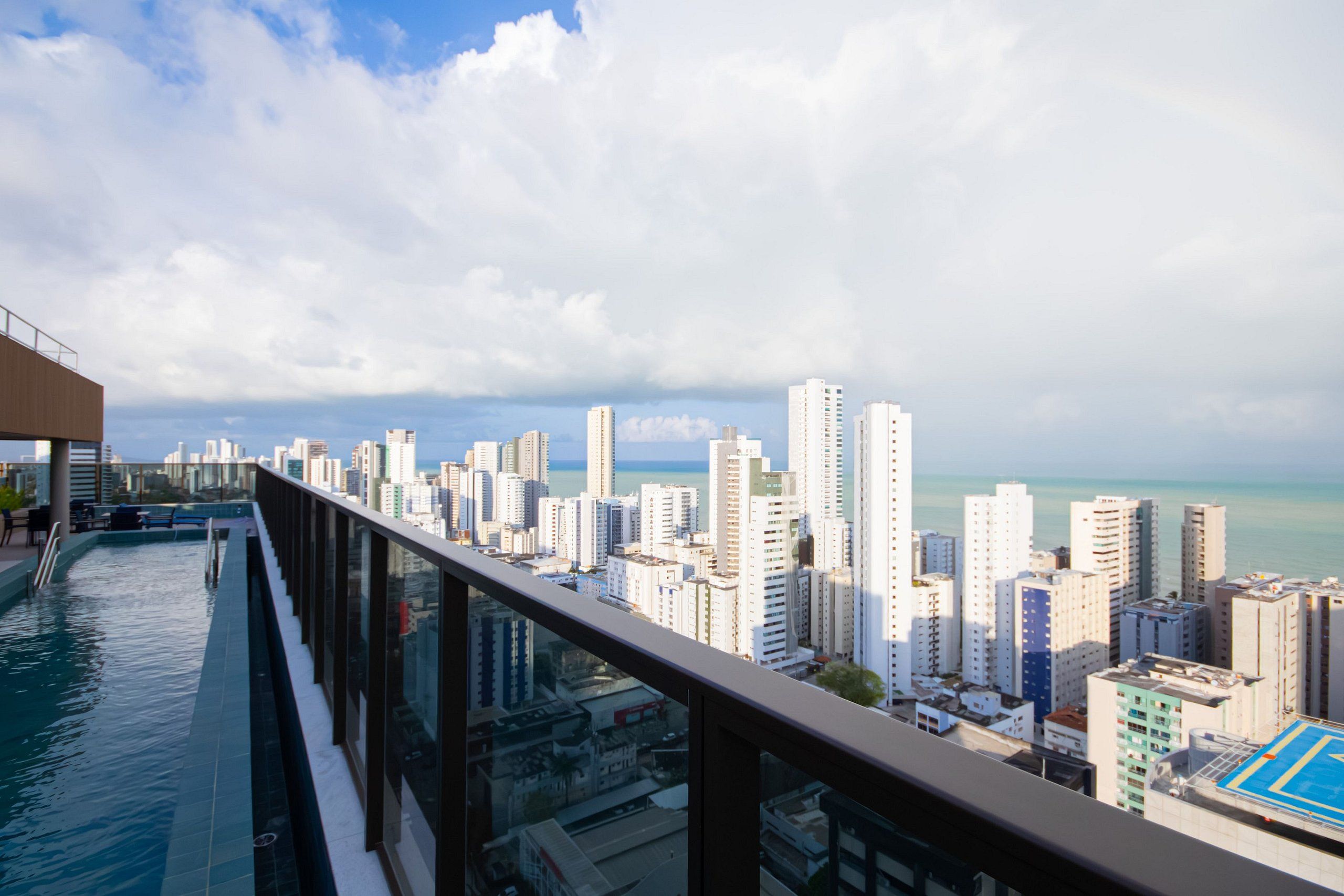 Um edifício alto com piscina e vista para a cidade.