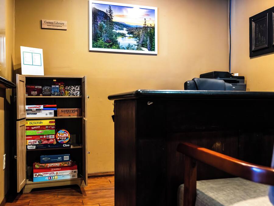 Uma biblioteca com uma placa indicando "Games Library" e uma pintura paisagística na parede.