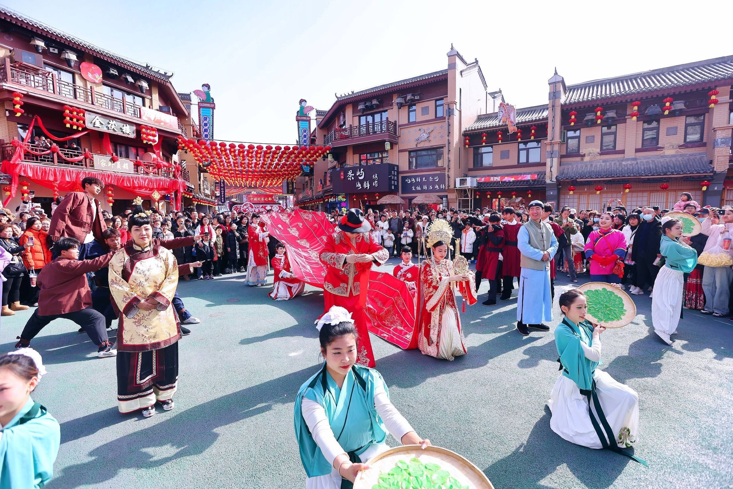 Um festival tradicional com pessoas em trajes históricos e decorações vermelhas.