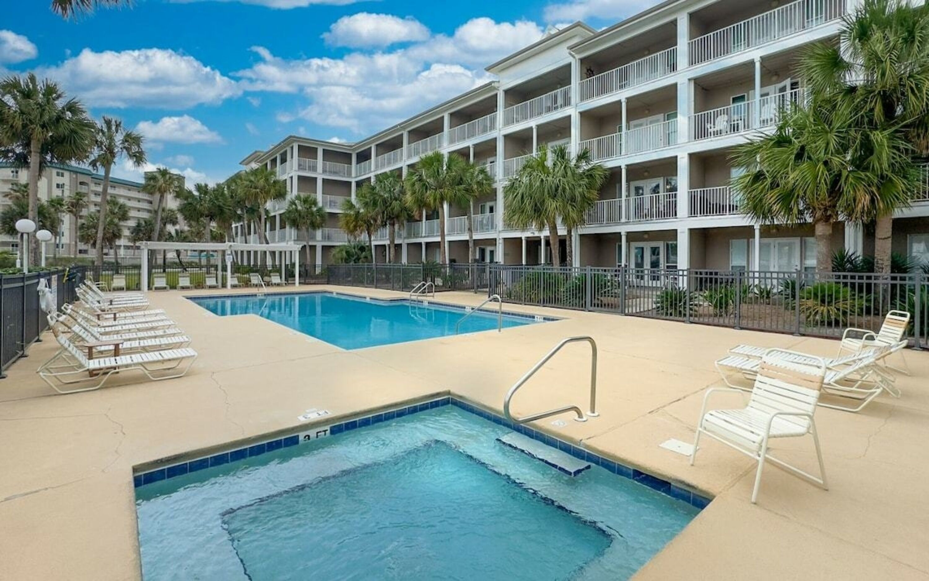 Um hotel com área de piscina, incluindo duas piscinas e espreguiçadeiras.