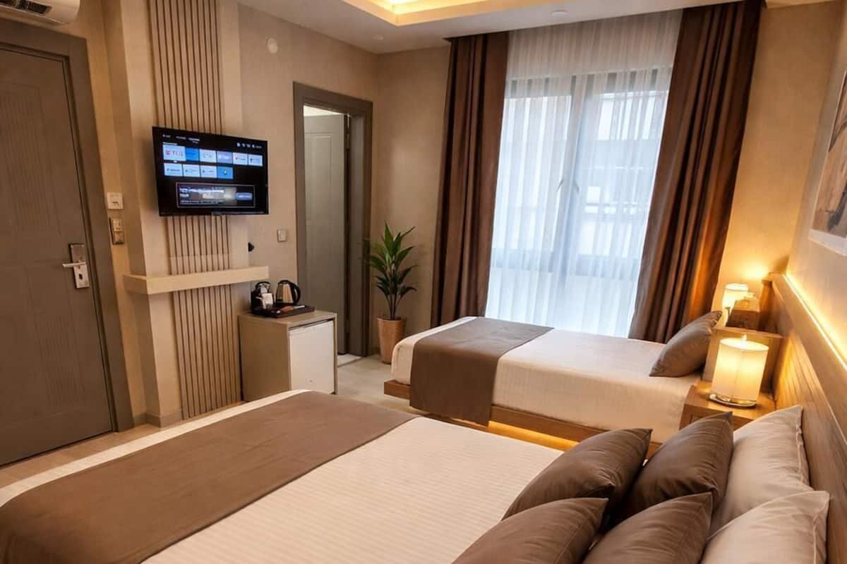 Quarto triplo família, vista para a cidade | Roupas de cama premium, frigobar, escrivaninha, quartos à prova de som