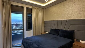 Quarto moderno com uma cama grande, uma mesa de cabeceira e um lustre.