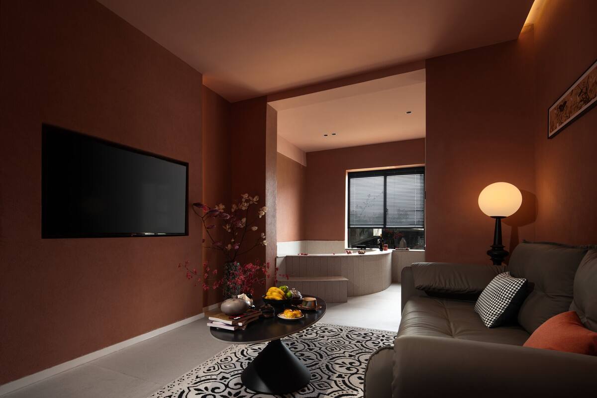 Uma sala de estar moderna com televisão de tela plana, um sofá, uma mesa de centro e um abajur.