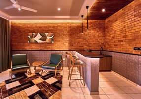 Decoração moderna com parede de tijolos, área de bar e disposição de assentos.