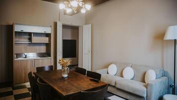Um espaço compacto com mesa de jantar, sofá e cozinha compacta.