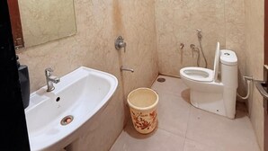 Uma casa de banho com lavatório, sanita e chuveiro.