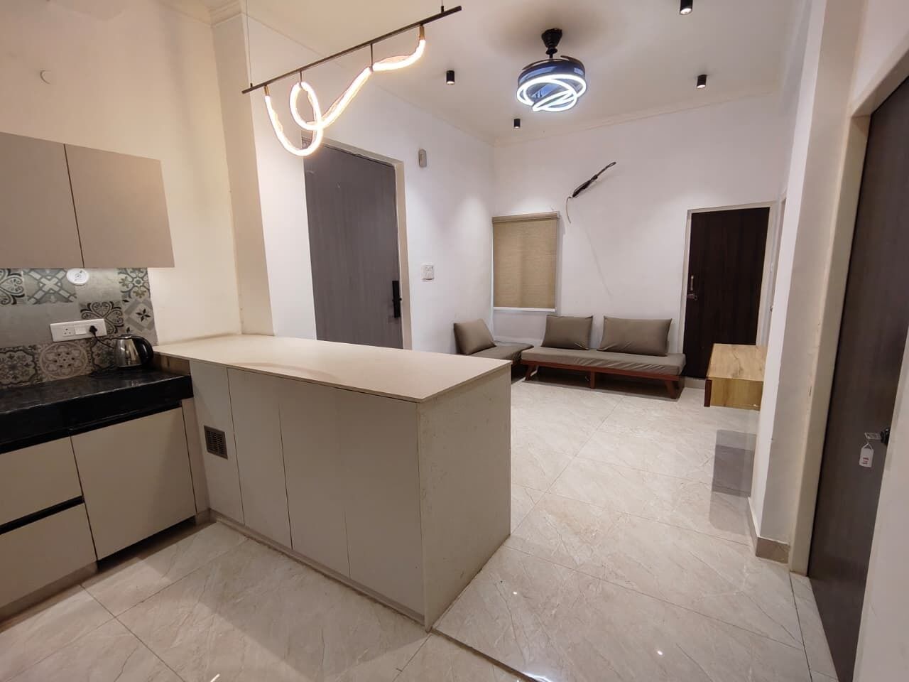 Uma cozinha moderna com uma ilha central, uma área de jantar com sofá e um ventilador de teto.