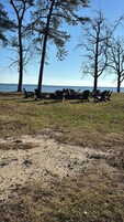 Uma praia com várias cadeiras Adirondack dispostas em semicírculo, voltadas para a água.