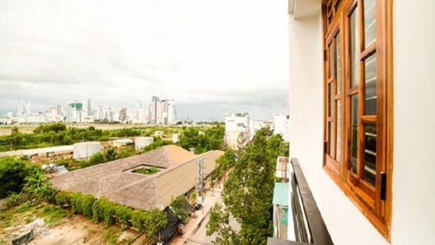 Uma varanda com vista para um horizonte urbano, incluindo edifícios e áreas verdes.
