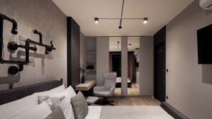 Quarto moderno com cama grande, uma cadeira, escrivaninha e espelho.