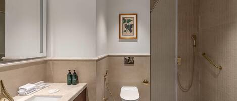 Uma casa de banho moderna com um espelho grande, lavatório, sanita e cabine de duche.