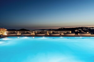 Piscina com vista para colinas distantes e uma ponte.