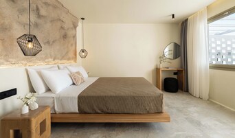 Quarto moderno com cama, mesas de cabeceira, espelho fixado na parede e janela com cortinas.
