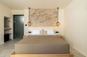 Quarto moderno com uma cama grande, duas mesas de cabeceira, um guarda-roupa e uma cabeceira com design texturizado.