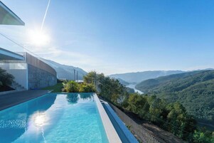 Piscina moderna com vista clara para uma paisagem montanhosa.