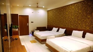 Quarto de hotel com duas camas, uma televisão e um painel decorativo.