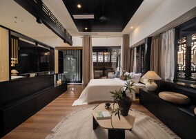 Quarto de hotel moderno com uma cama grande, uma escrivaninha, uma TV e uma varanda.