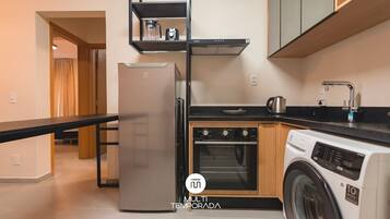 Apartamento Deluxe, acesso à piscina, vista para a praia | Cozinha privada | Um frigorífico, um micro-ondas, utensílios de cozinha, mesas de jantar