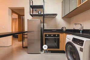 Apartamento Deluxe, acesso à piscina, vista para a praia | Cozinha privada | Um frigorífico, um micro-ondas, utensílios de cozinha, mesas de jantar 