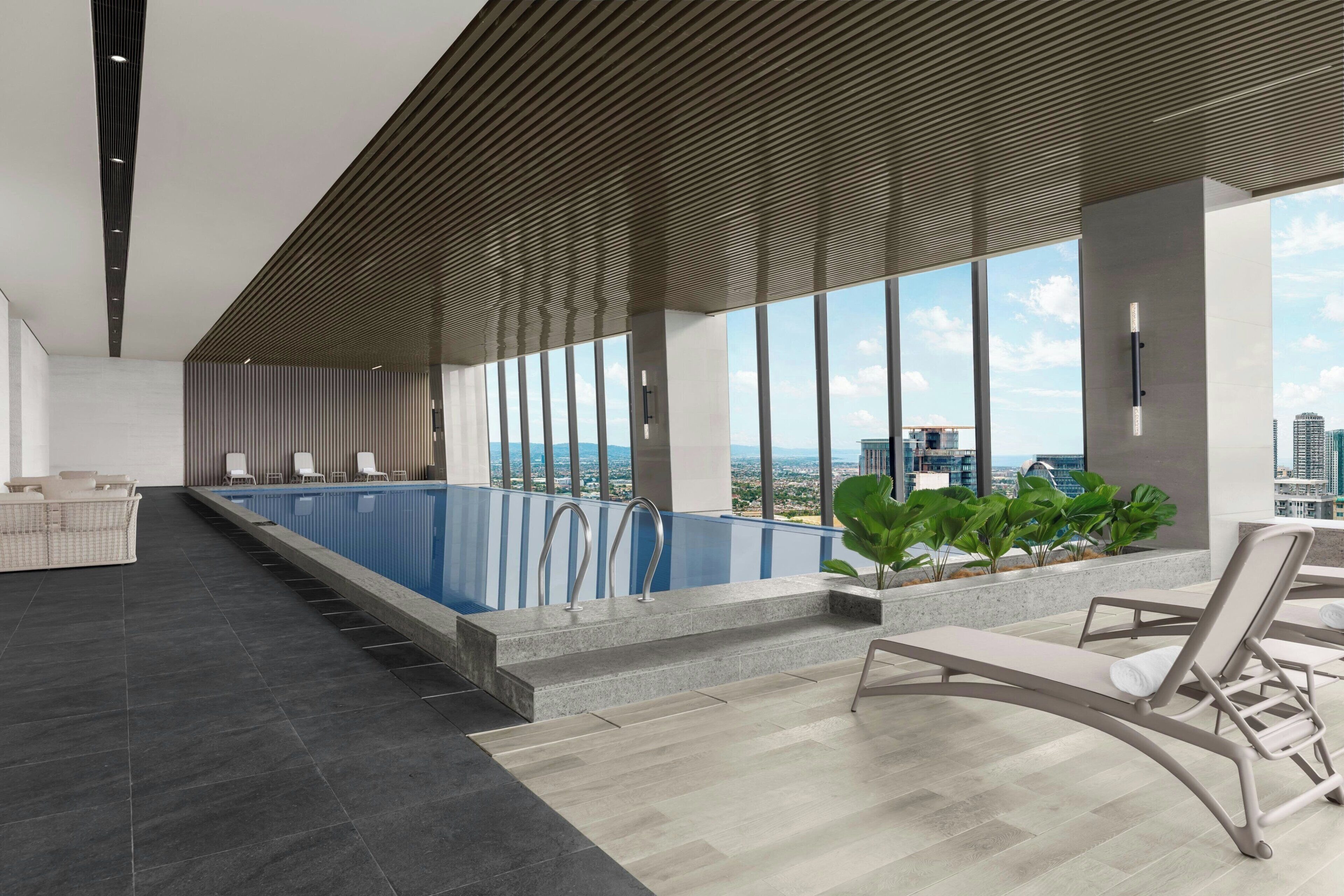 Uma área interna de piscina moderna com vista para a paisagem urbana.