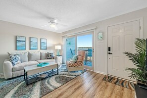 Condo com design assinado, 1 quarto, sacada, vista para a praia | Sala de estar | Smart TV 32 polegadas com canais via satélite