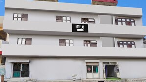 Um edifício de vários andares com uma placa indicando 'HOTEL' e o logotipo da empresa.