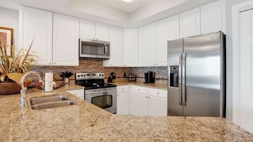 Condo com design assinado, 3 quartos, sauna seca, vista para a praia | Cozinha privada | Geladeira, micro-ondas, fogão, cooktop