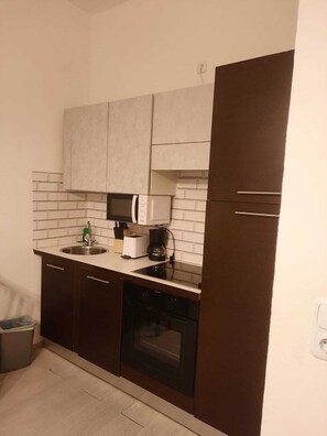 Apartamento Básico | Cozinha privada | Um micro-ondas, um forno, uma placa de cozinha, utensílios de cozinha 