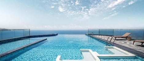 Chuveiro, secador de cabelo, chinelos, toalhas de banho