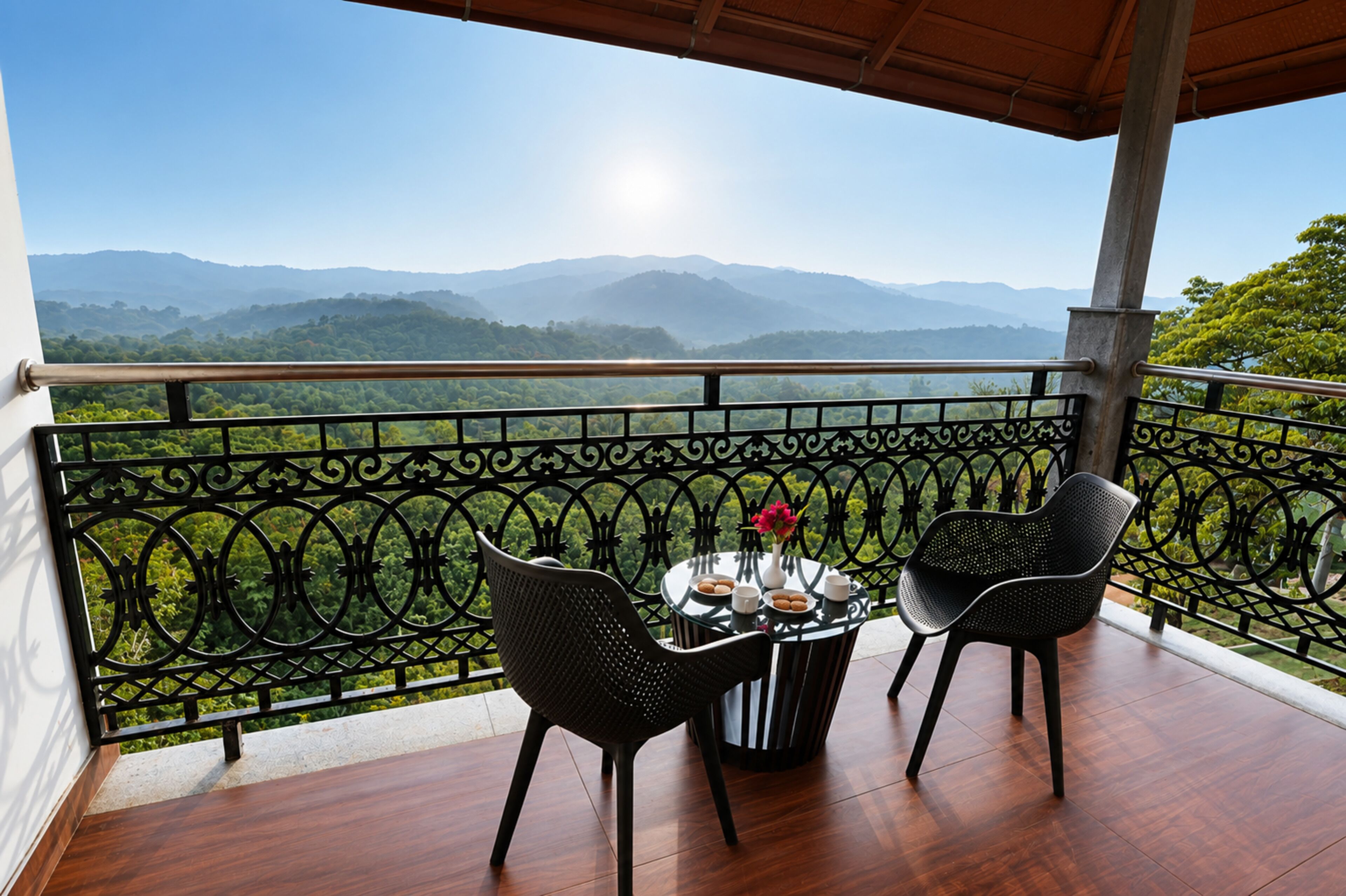 Uma varanda com mesa e cadeiras, com vista para uma paisagem montanhosa.