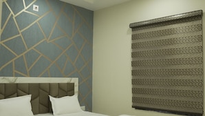 Quarto com cama, ventoinha no teto e parede estampada.