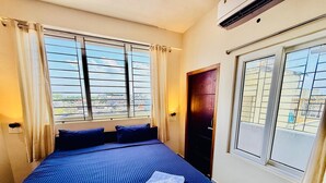 Quarto de hotel com uma cama grande, duas almofadas, um controle remoto e uma toalha sobre a cama.