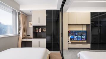 Quarto de hotel moderno com cama, escrivaninha e guarda-roupa.