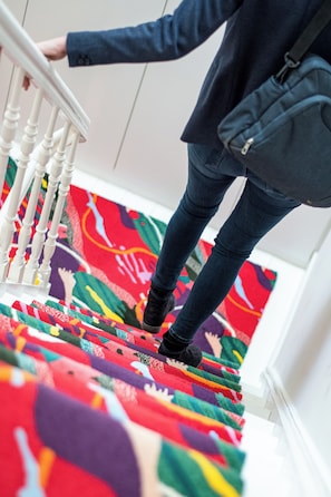 Uma pessoa descendo uma escadaria com um tapete colorido.