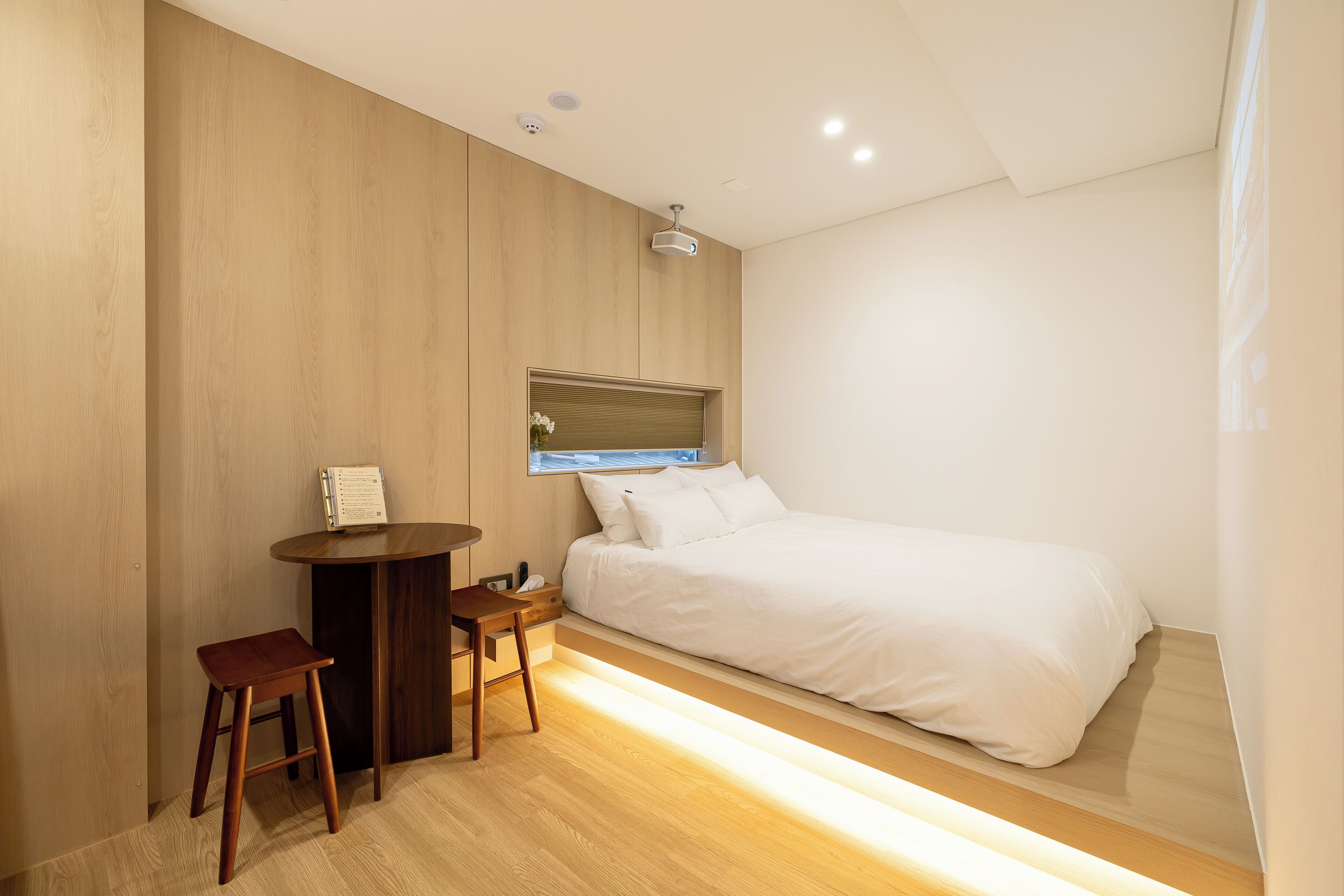 Quarto com uma cama, uma escrivaninha e uma cadeira.
