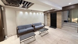 Uma sala de estar moderna com dois sofás, uma mesa de centro e uma parede com padrão.