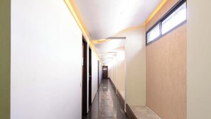 Um corredor comprido e estreito com piso de madeira e paredes brancas.