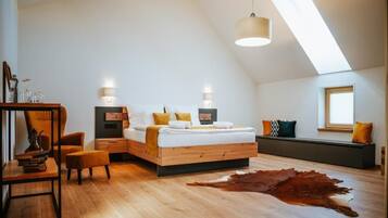 Quarto moderno com teto inclinado, uma cama grande, mesa de cabeceira de madeira, uma cadeira e um tapete de couro.