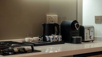 Estúdio superior, 1 cama King, sacada, vista para o canal | Cozinha privada | Talheres/pratos/utensílios de cozinha, mesas de jantar