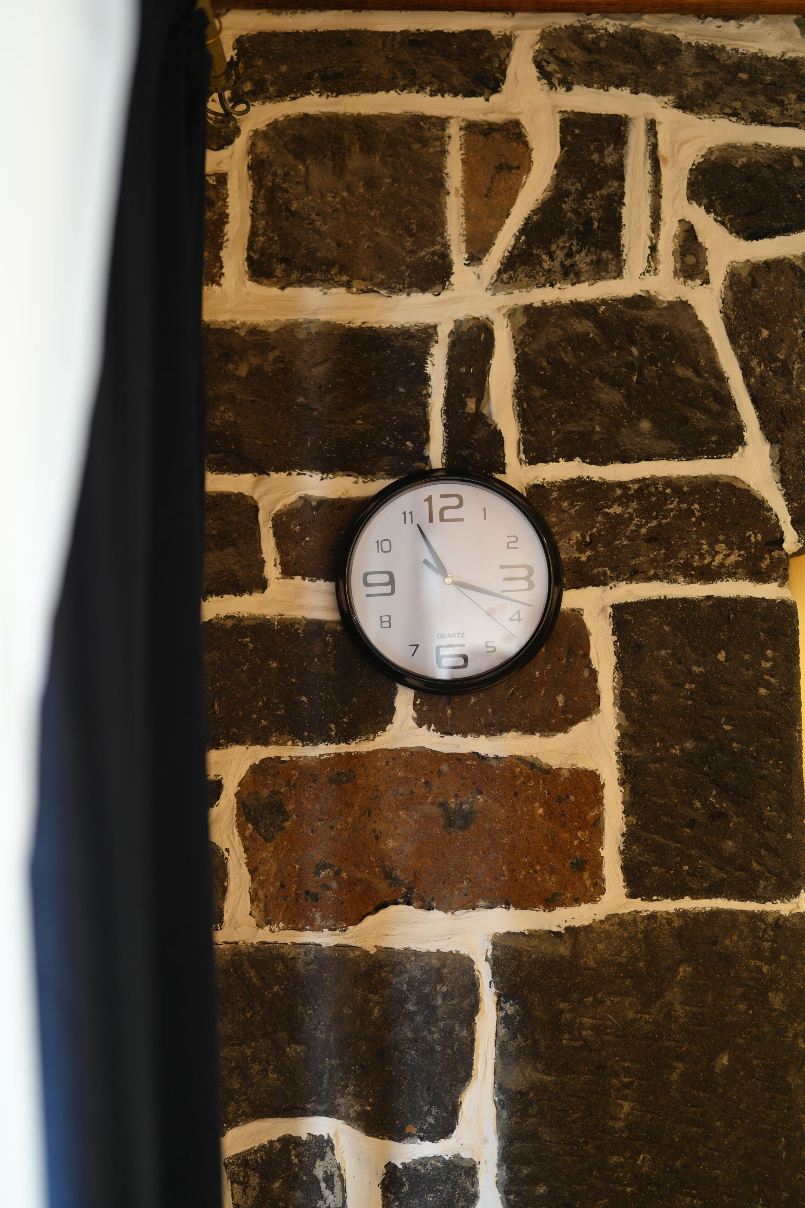 Um relógio fixado em uma parede de pedra.
