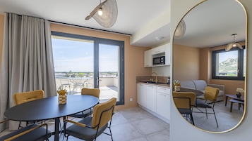 Um apartamento moderno com área de jantar, cozinha e varanda com vista.
