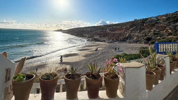 Vista costeira com varanda sobre a praia e o mar.