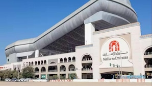 Exterior do Mall of the Emirates, com um telhado curvo característico e várias arcadas.