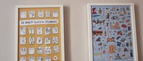 Duas obras de arte emolduradas retratando diversos aspectos da vida em Florença, incluindo acomodações e símbolos culturais.