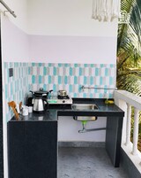 Cozinha compacta com fogão a gás, pia e bancada pequena.