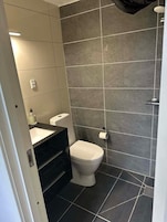 Quarto Comfort, pátio | Casa de banho | Um polibã, um secador de cabelo, toalhas fornecidas, papel higiénico